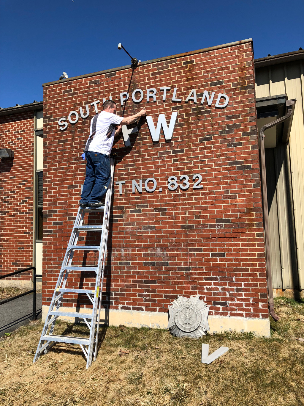 Removing the VFW lettering from the building – Maine Military Museum